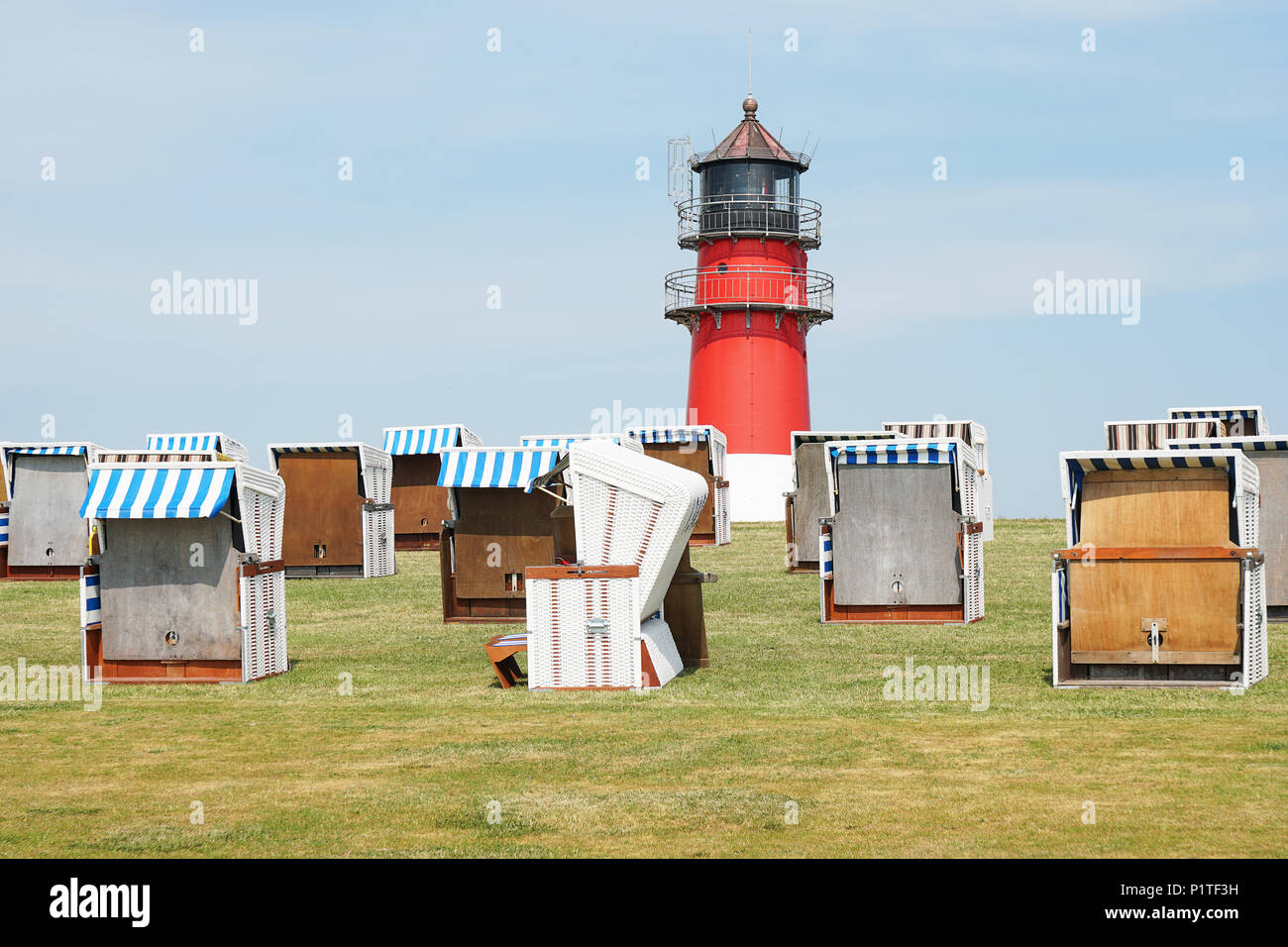 dike or dyke with hooded beach chairs and lighthouse in Buesum, Germany ...