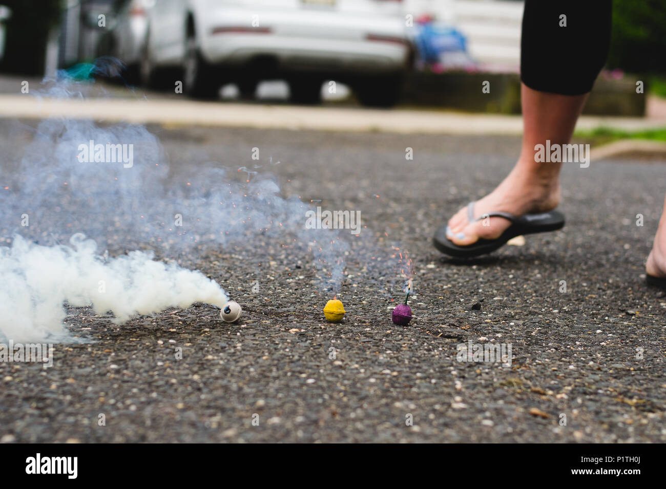 Three Smoke Bombs by Woman's Foot in Street Stock Photo - Alamy
