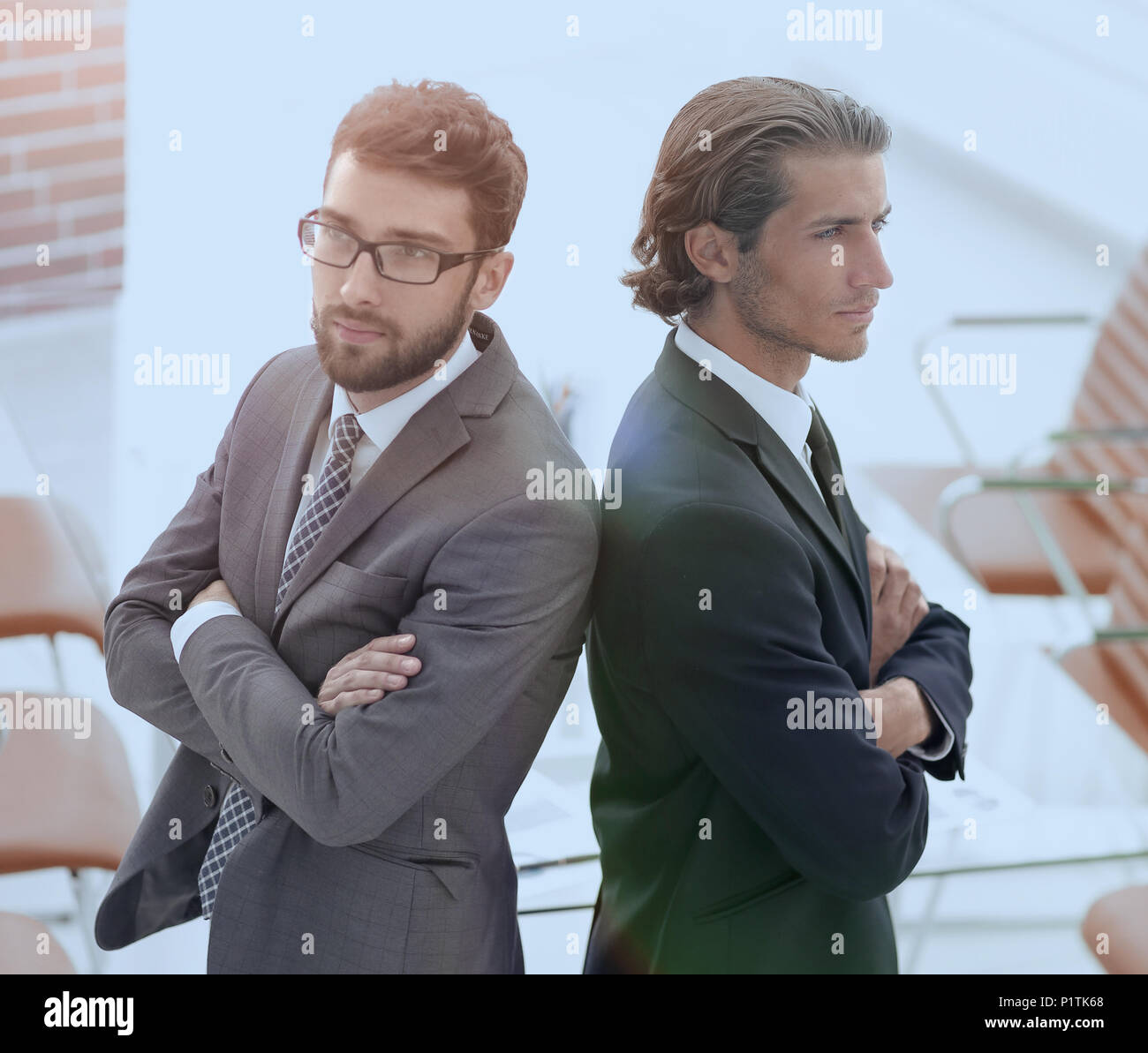 Two men standing back to back and support each other Stock Photo - Alamy