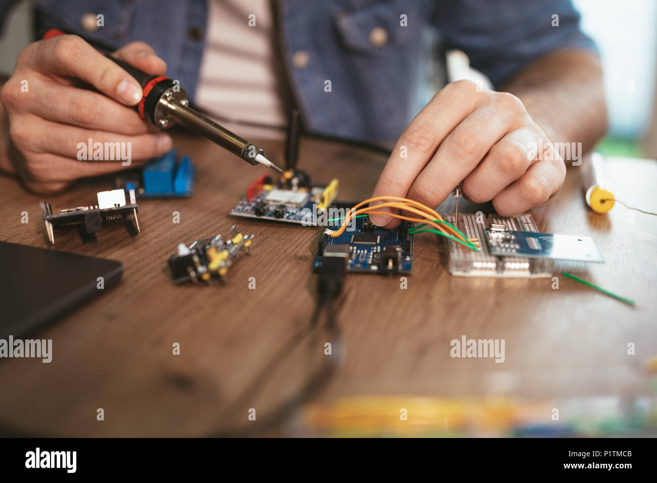 Close-up of a male hands soldering circuit board by soldering iron on ...