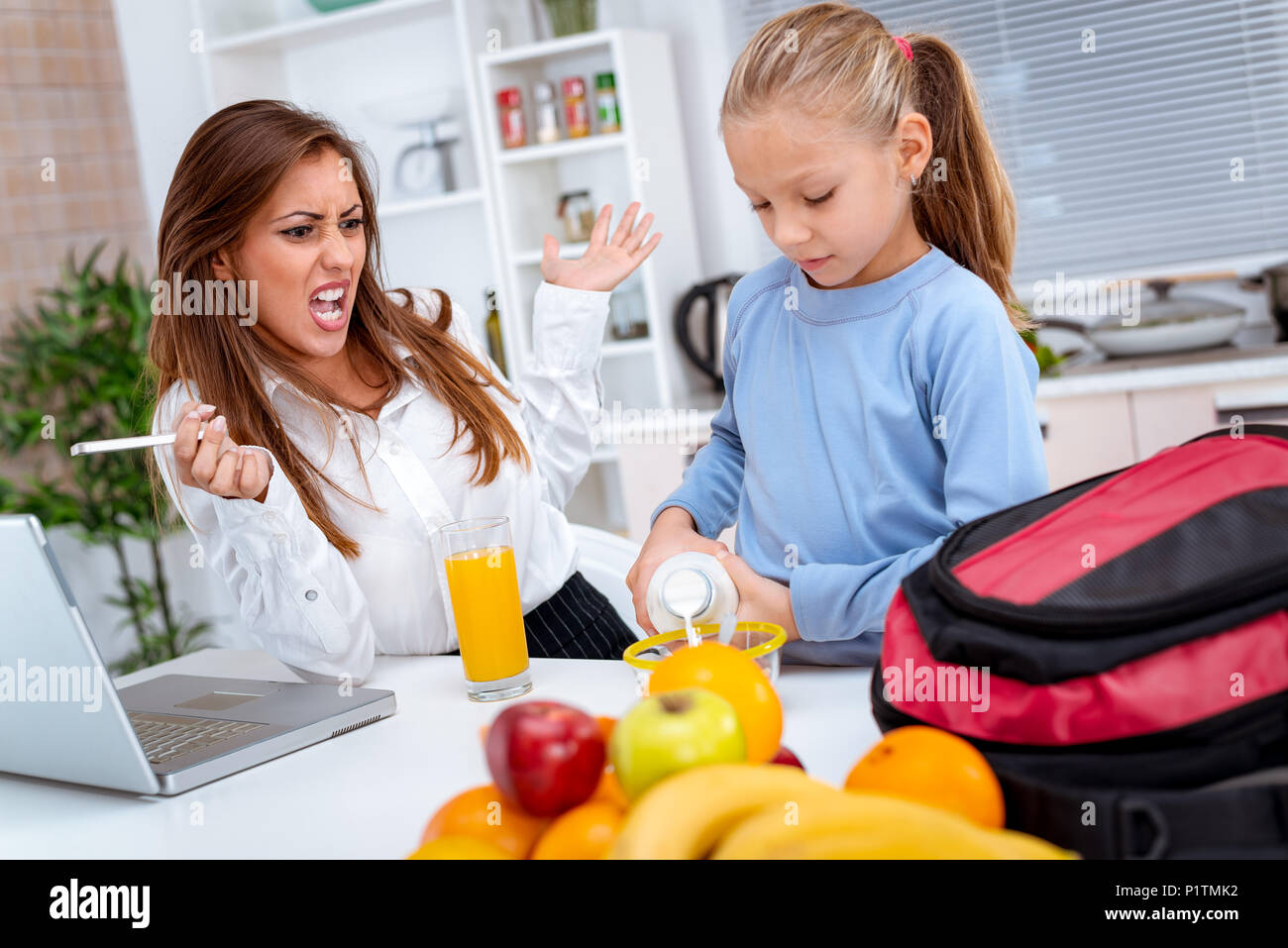 Overworked mother rushing her daughter in the morning to go faster ...