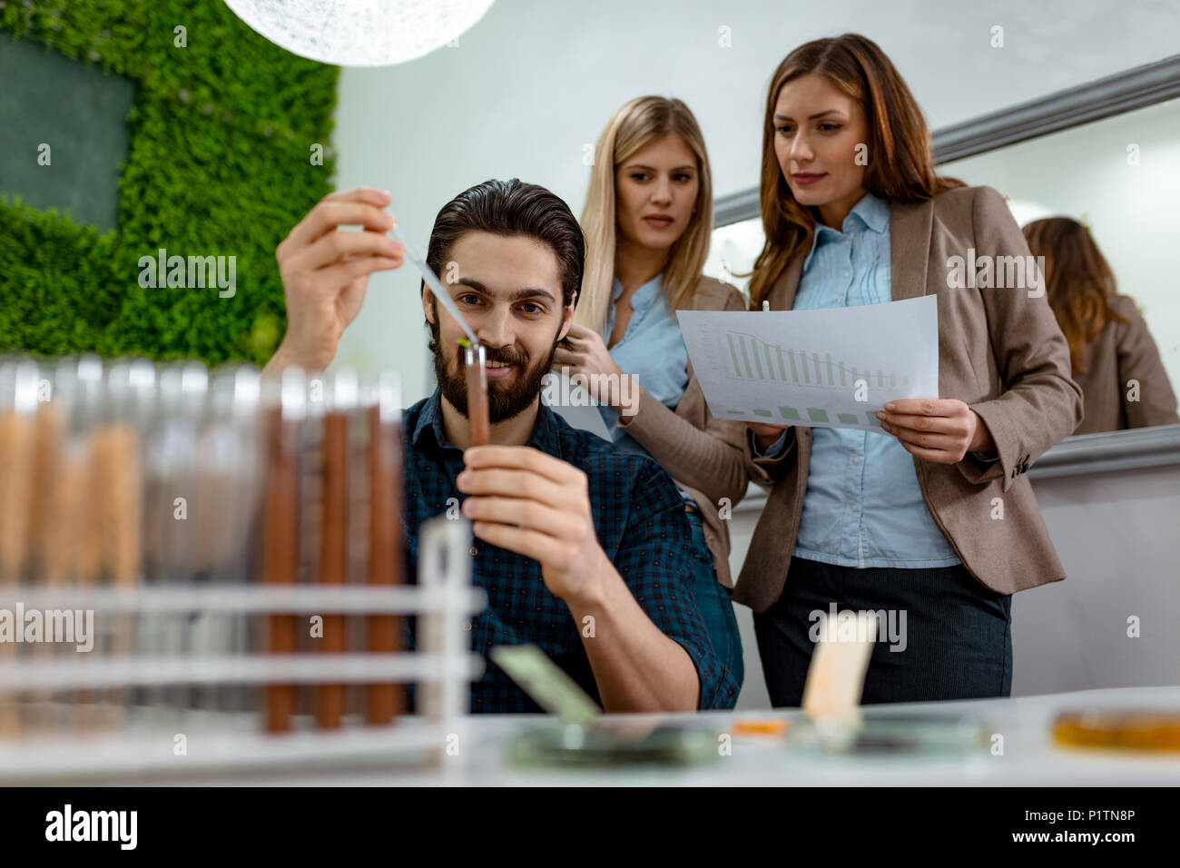 Team of a university biologists analysing the sample of plant in the ...