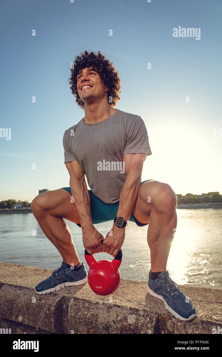 Bodybuilder is crouching and doing strong fit body training with ...