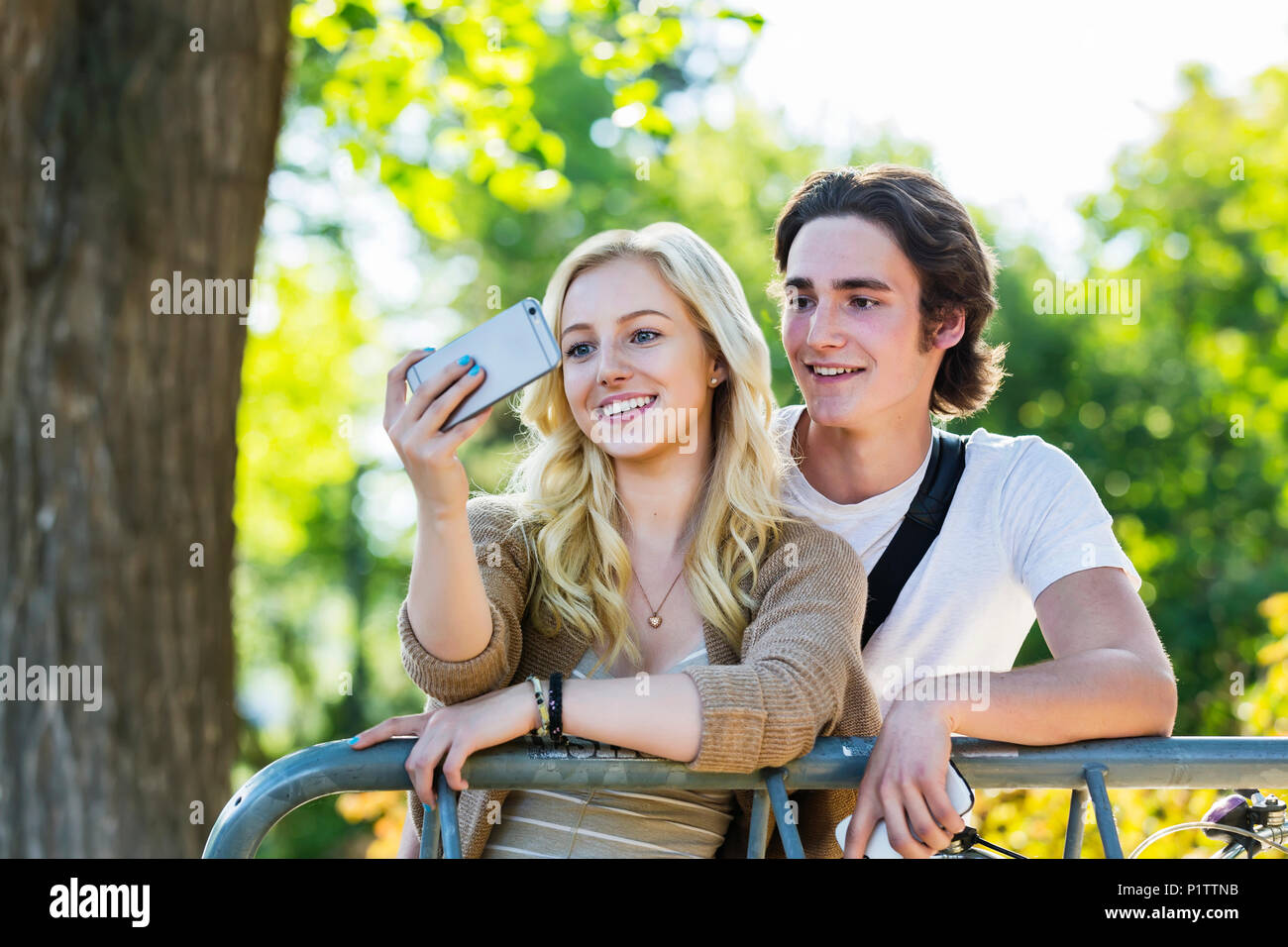A young couple stands together at a bike rack on the university campus ...
