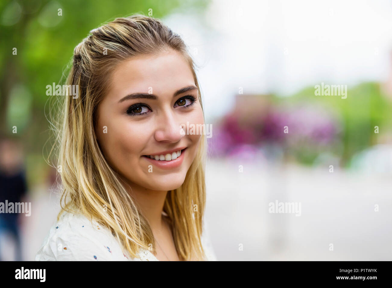 Portrait of a beautiful young woman on a university campus with the ...