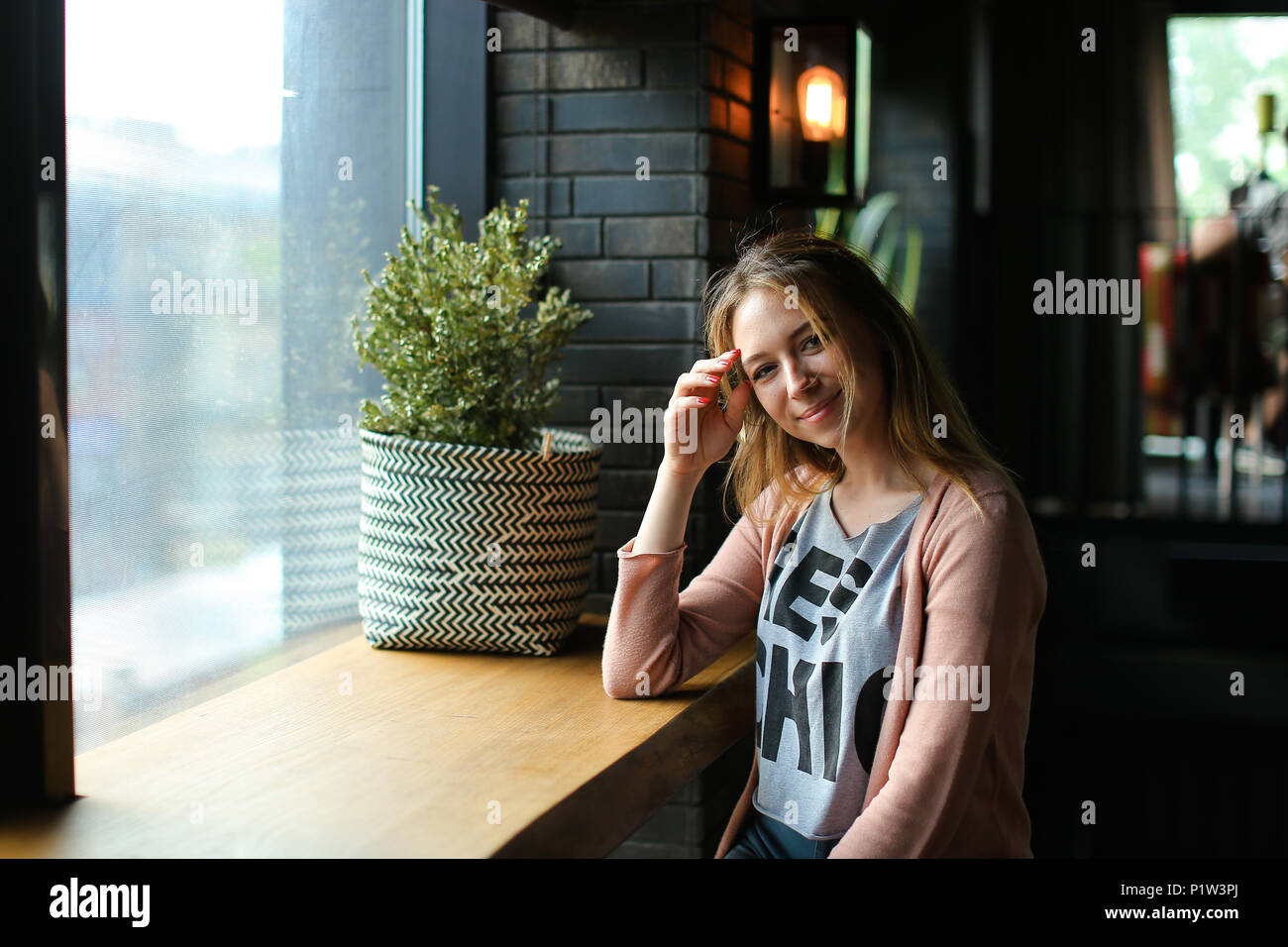 Pretty woman sitting at cafe and smiling Stock Photo - Alamy