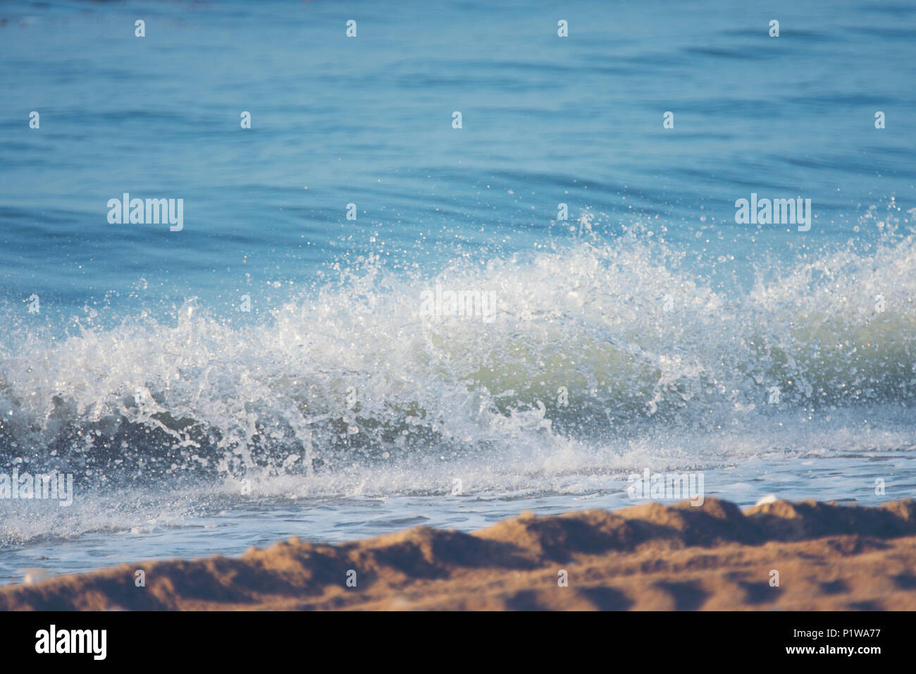 Waves breaking sand beach Stock Photo - Alamy