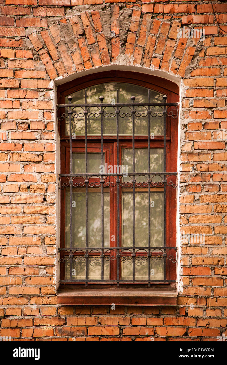 Close-up of an old wooden window with divided grilles in an old red ...