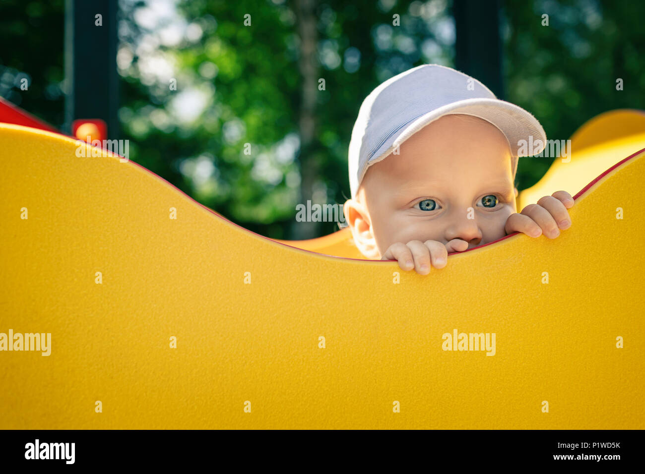 Baby boy playing in playground alone. Portrait of toddler looking away ...
