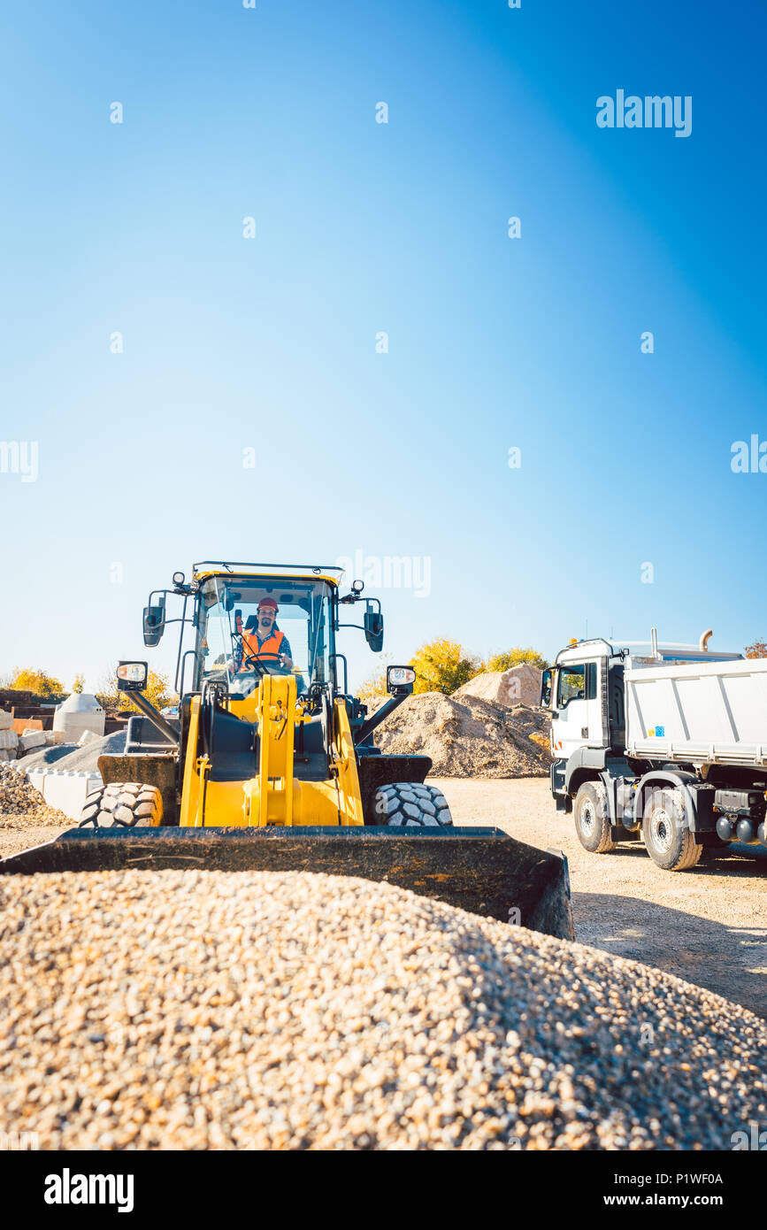 Construction workers doing earthworks with wheel loader and rubble ...