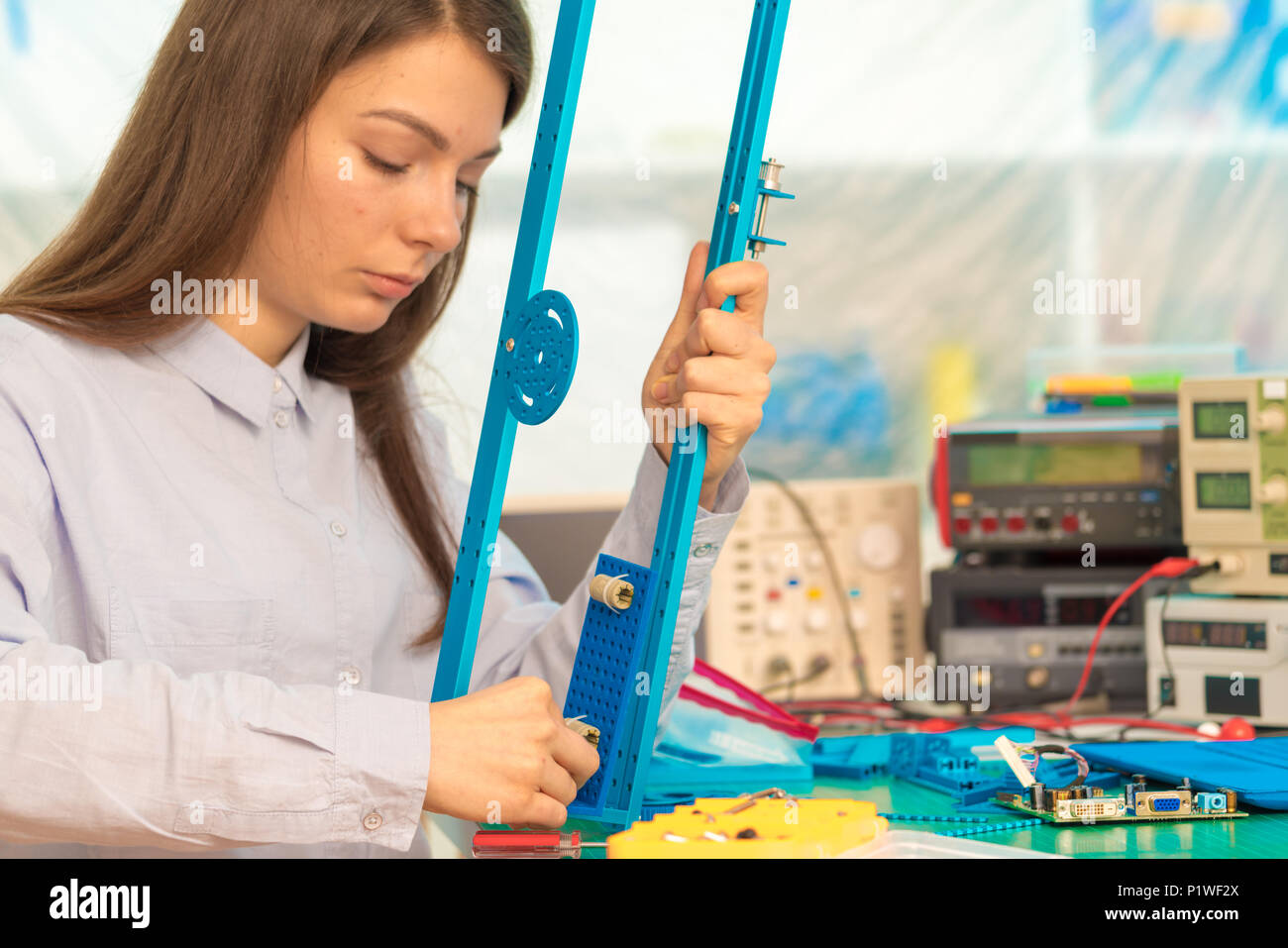 Female student in electronics class uses a Measuring device Stock Photo ...
