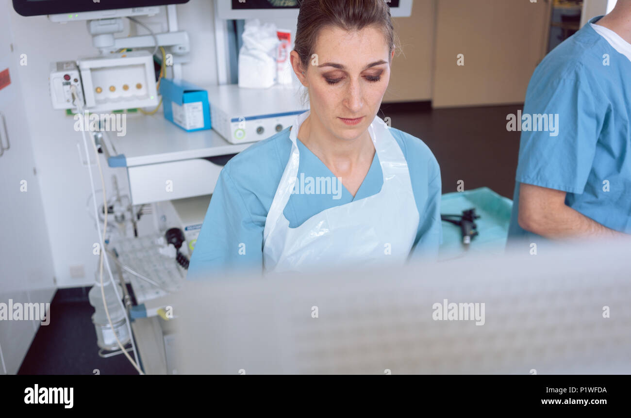 Internal specialist doctor looking at screen mid examination in a ...