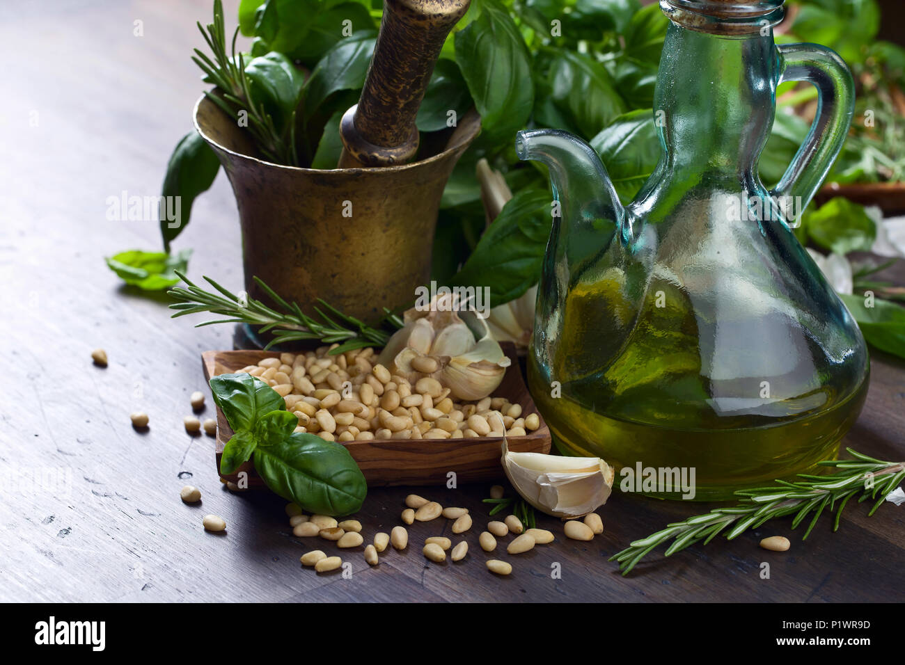 Old copper mortar with olive oil, garlic, green basil and pine nuts ...