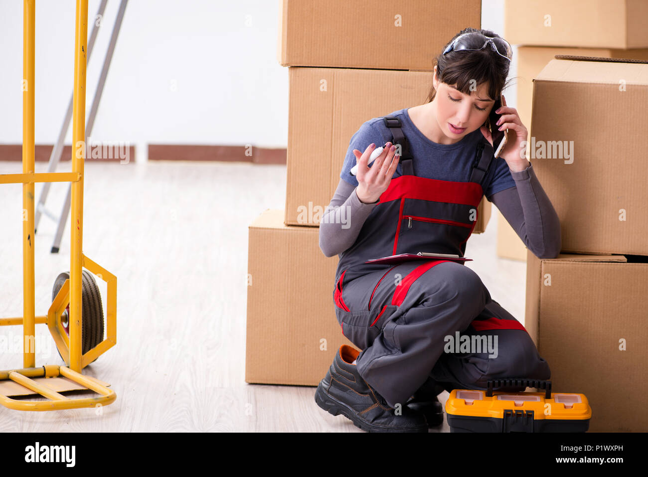 Woman contractor moving boxes in relocation concept Stock Photo - Alamy