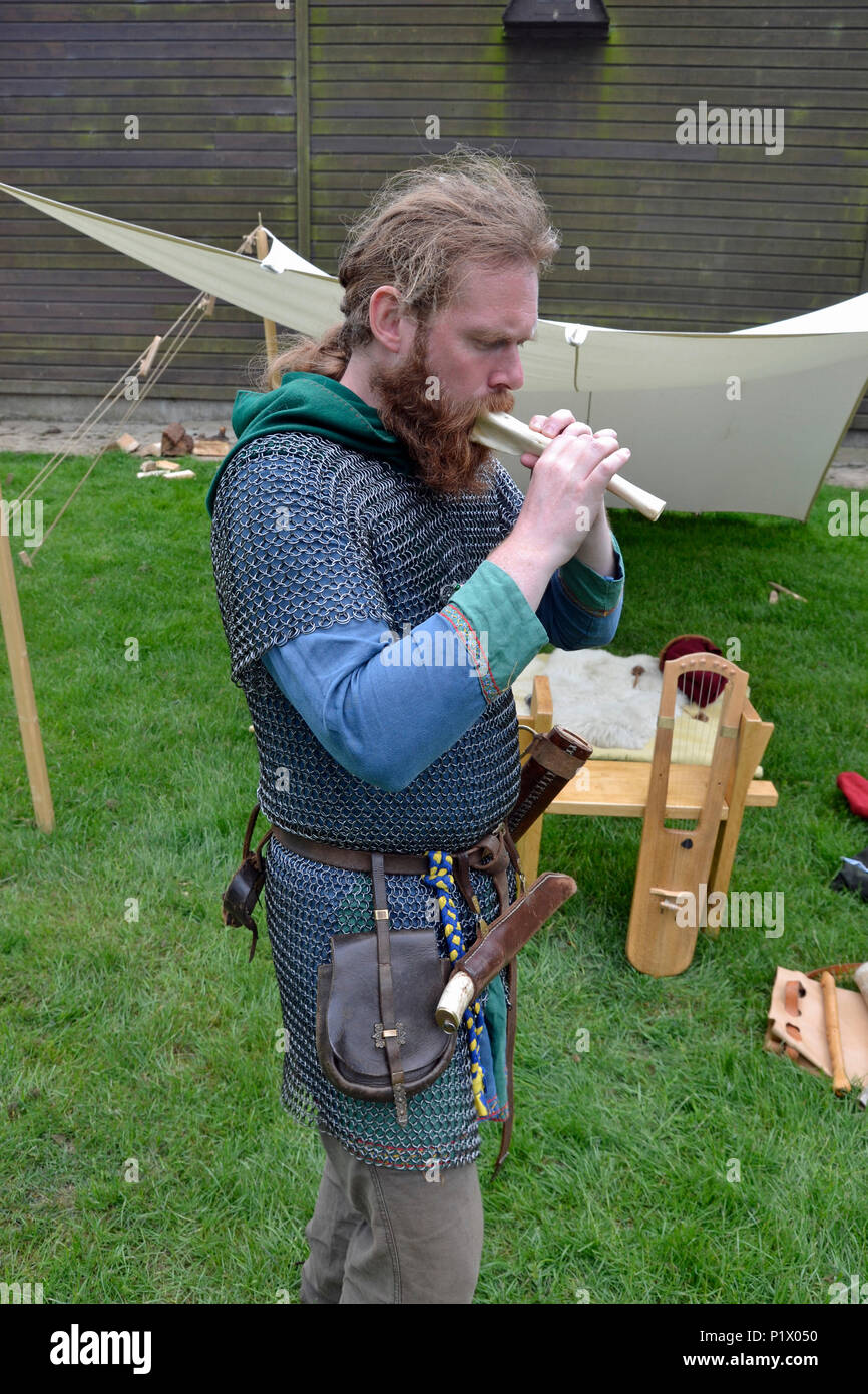 Medieval musician playing a flute at Flag Fen Archaeology Park. Anglo ...