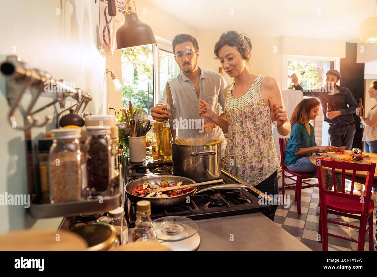 Mixed group of friends have fun while cooking a meal in kitchen Stock ...