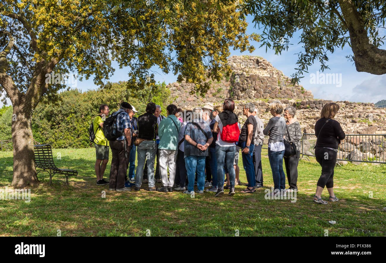 A guide and visitors at Nuraghe Su Nuraxi, UNESCO World Heritage Site ...