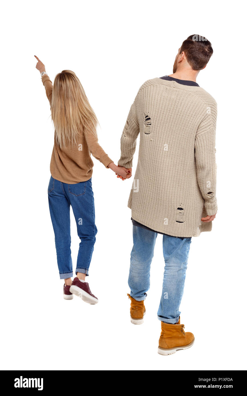 Back view of going couple. walking friendly girl and guy holding hands ...