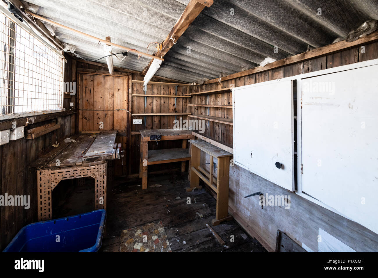 Interior of an old abandoned shed with homemade workbench, cupboards ...