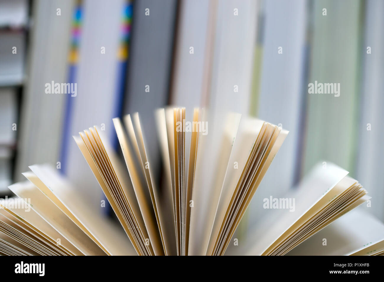 Open book, stack of hardback books on table. Top view Stock Photo - Alamy