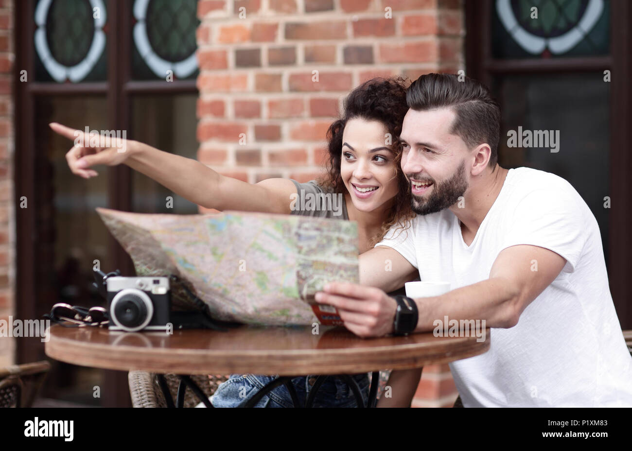 Young tourists having coffee at cafe and reading map Stock Photo - Alamy