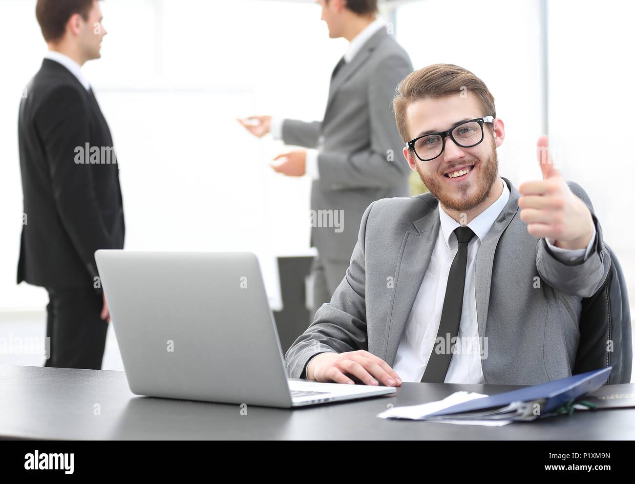 Manager sitting at his Desk and showing thumbs up Stock Photo - Alamy