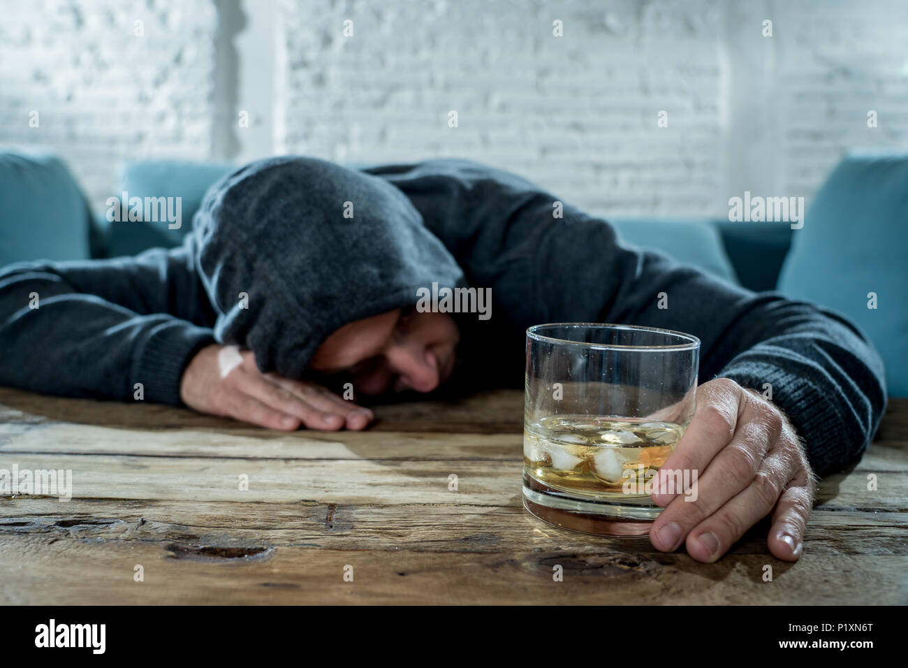 drunk alcoholic unemployed man drinking whiskey from the glass and bottle depressed wasted and ...