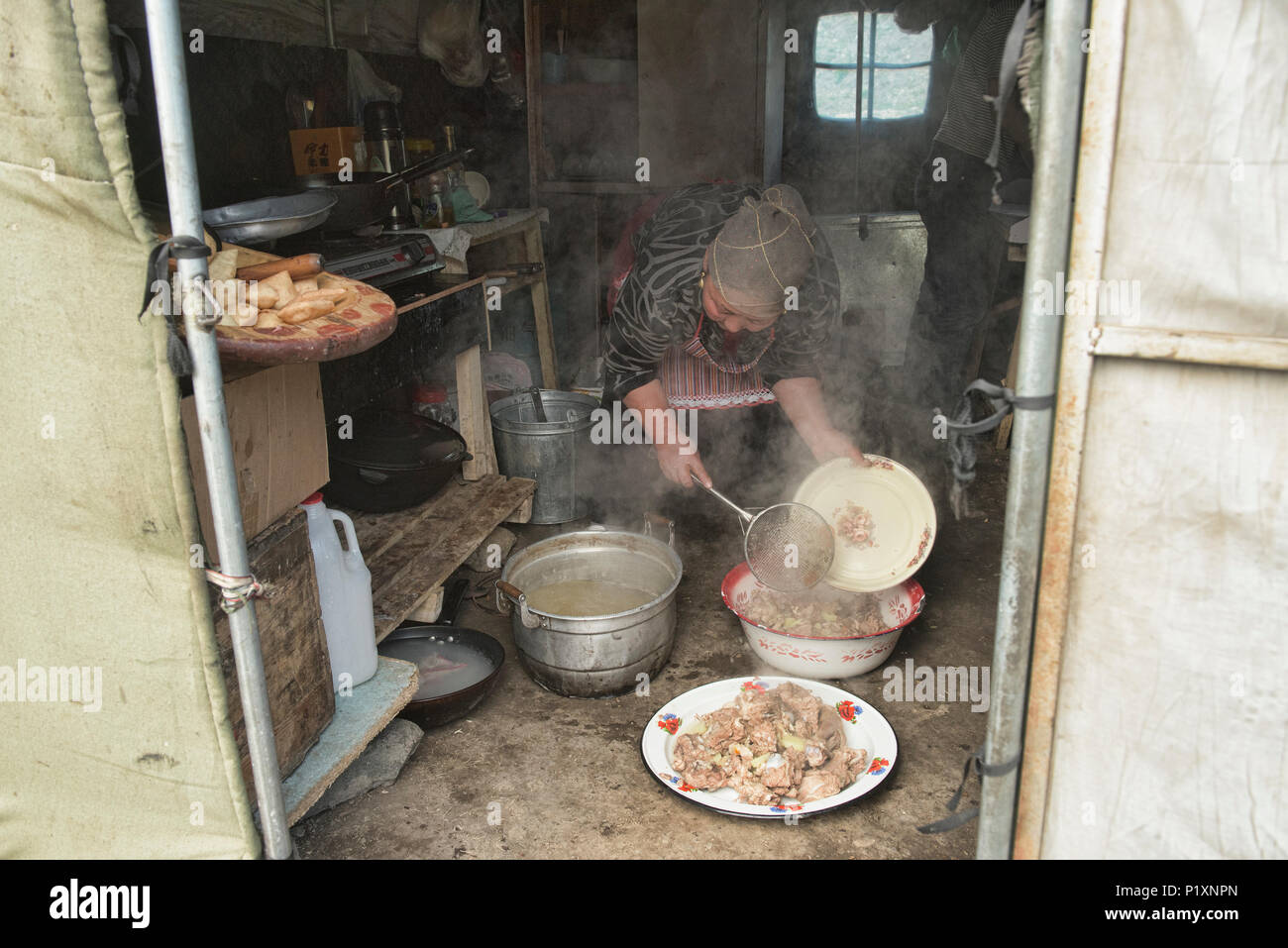Kazakh woman cooking mutton, Sayram Lake, Xinjiang, China Stock Photo ...