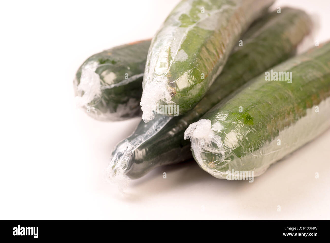 Bunch of cucumber wrapped in plastic films, isolated on white ...