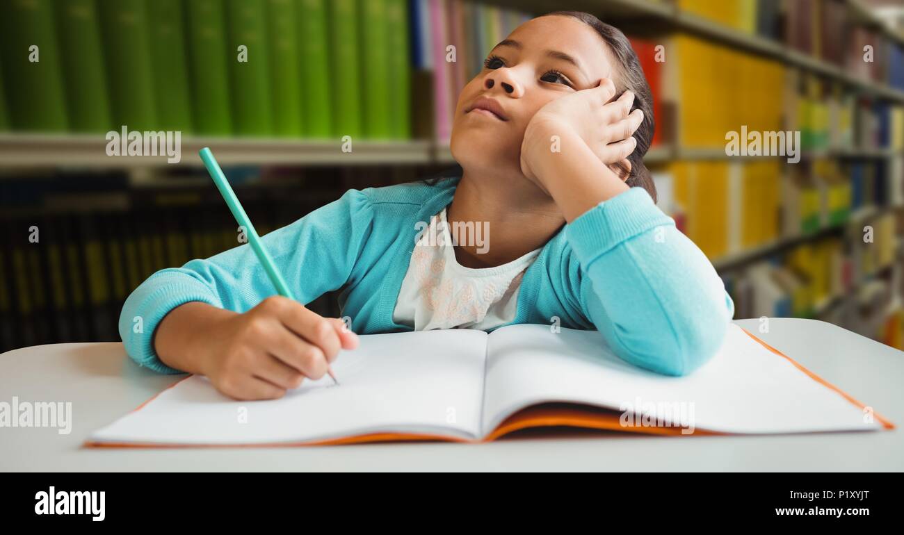 Girl doing schoolwork in education library Stock Photo - Alamy