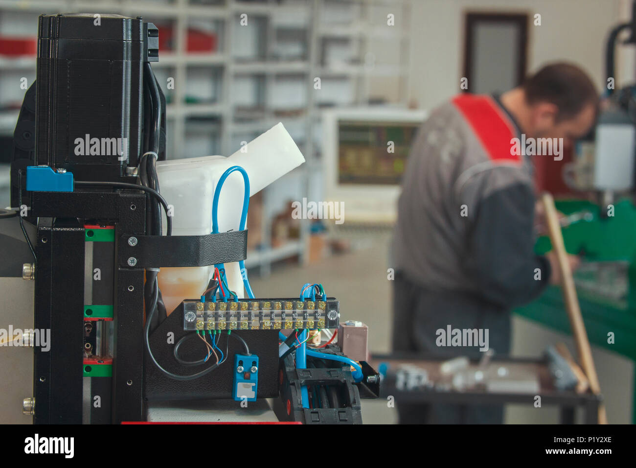 Working CNC machine at factory with lathes, man in uniform at ...