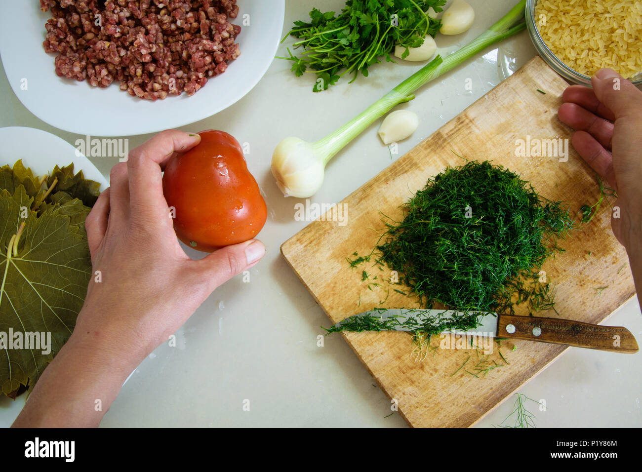 Top view of woman hands cooking a traditional meal with grape leaves ...