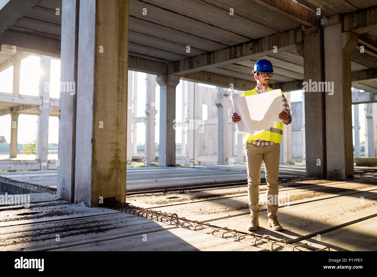 Picture of construction site engineer looking at plan Stock Photo - Alamy