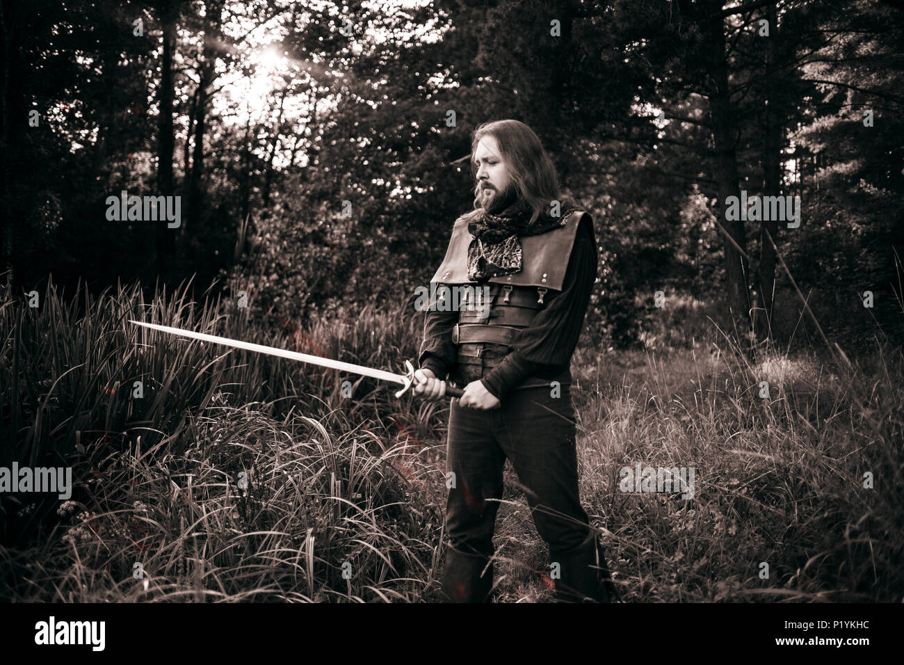 The bearded man knight. A guy in a medieval costume with a sword ...
