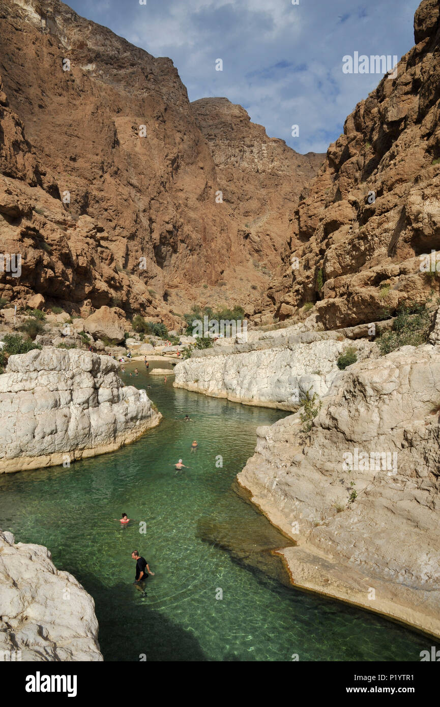 Sultanate of Oman, Wadi Shab, tourists are swimming in a turquoise blue ...