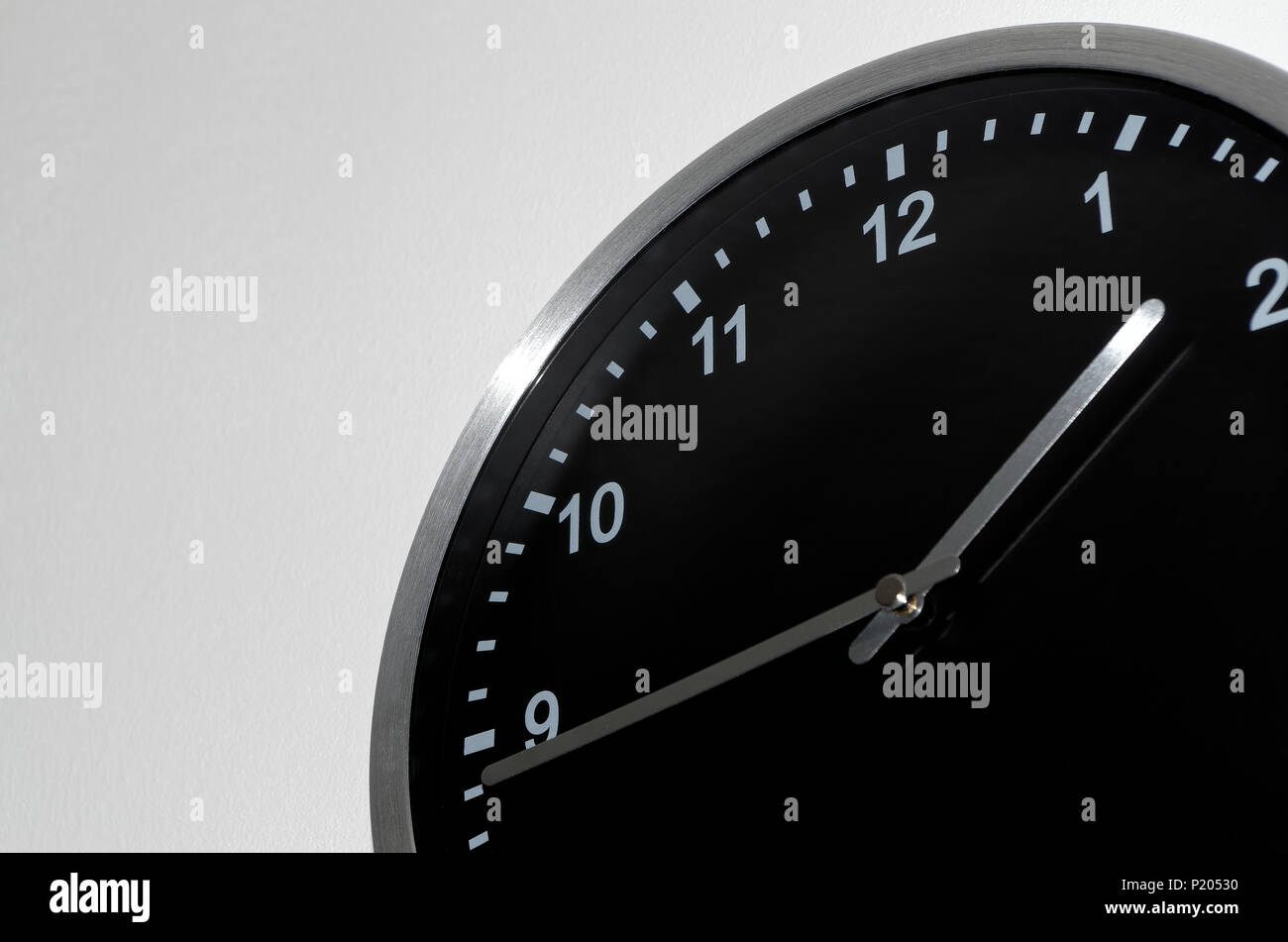 Quarter to two setting on the black wall clock Stock Photo - Alamy
