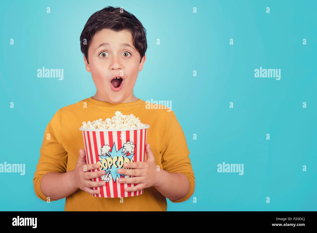 happy boy with popcorn on blue background Stock Photo - Alamy
