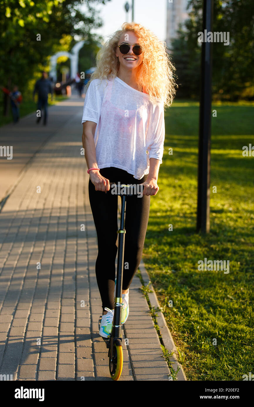 Pretty girl riding scooter hi-res stock photography and images - Alamy