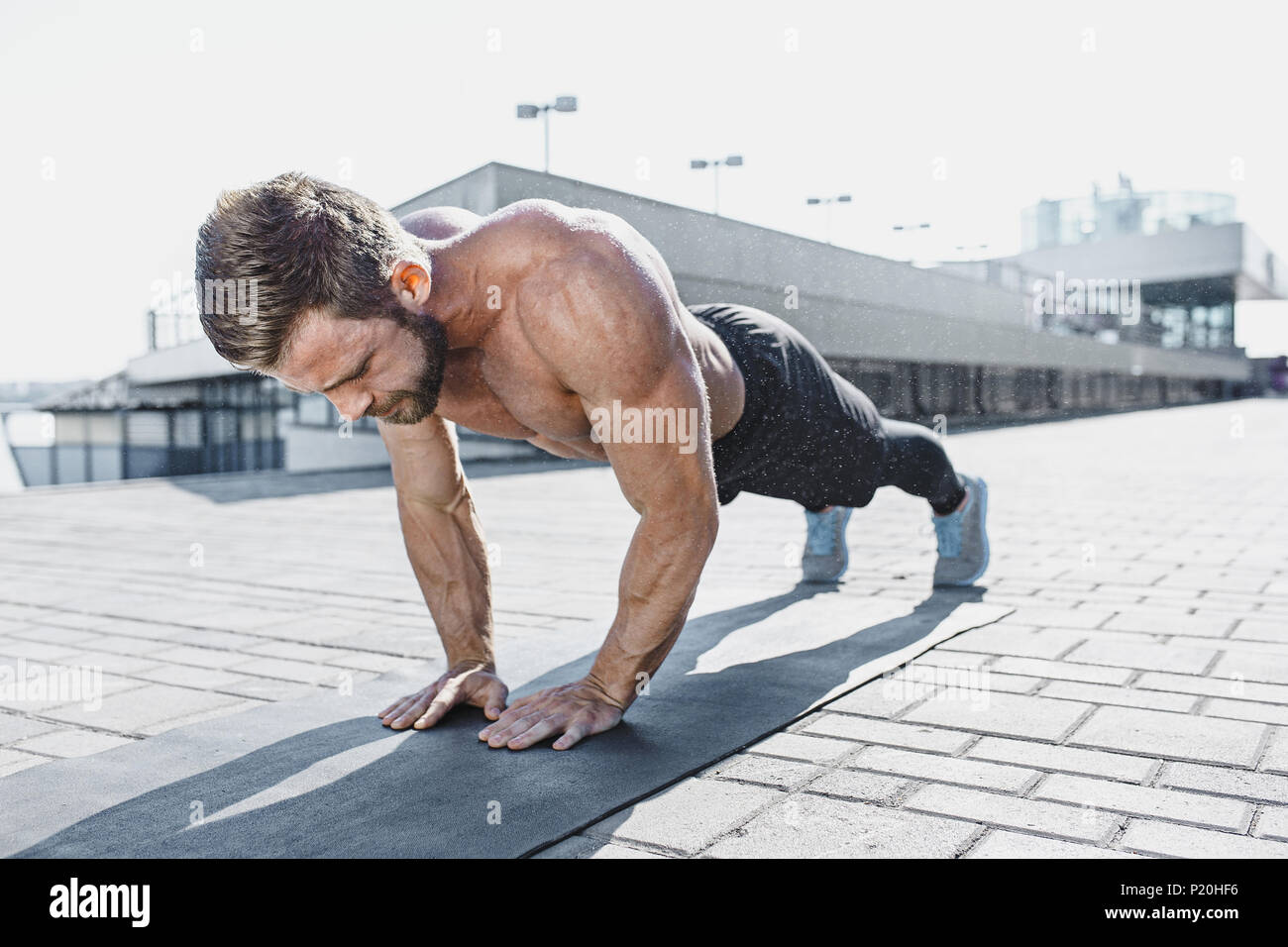 Fit fitness man doing fitness exercises outdoors at city Stock Photo ...