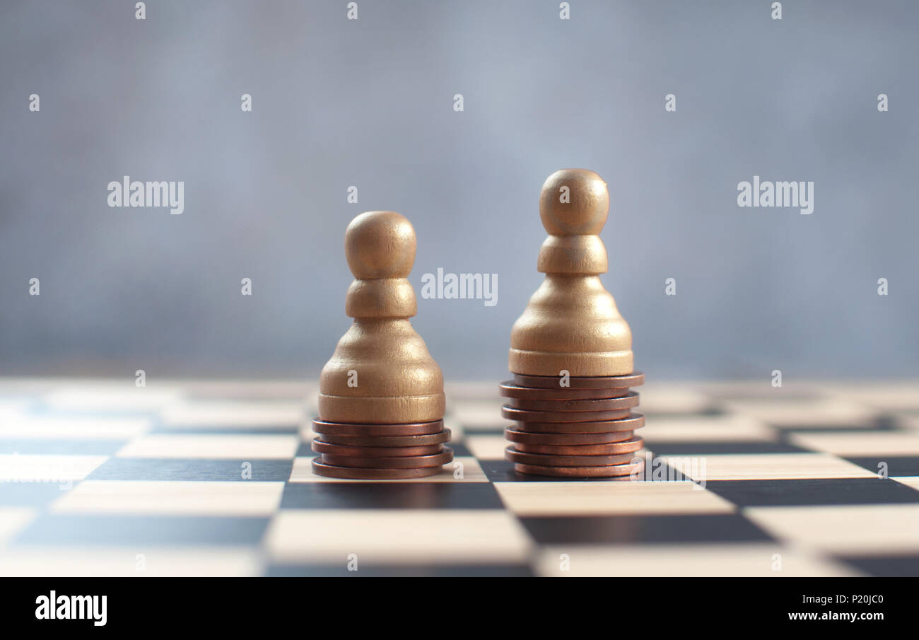 Two chess pawns with on top of a heap of coins Stock Photo - Alamy