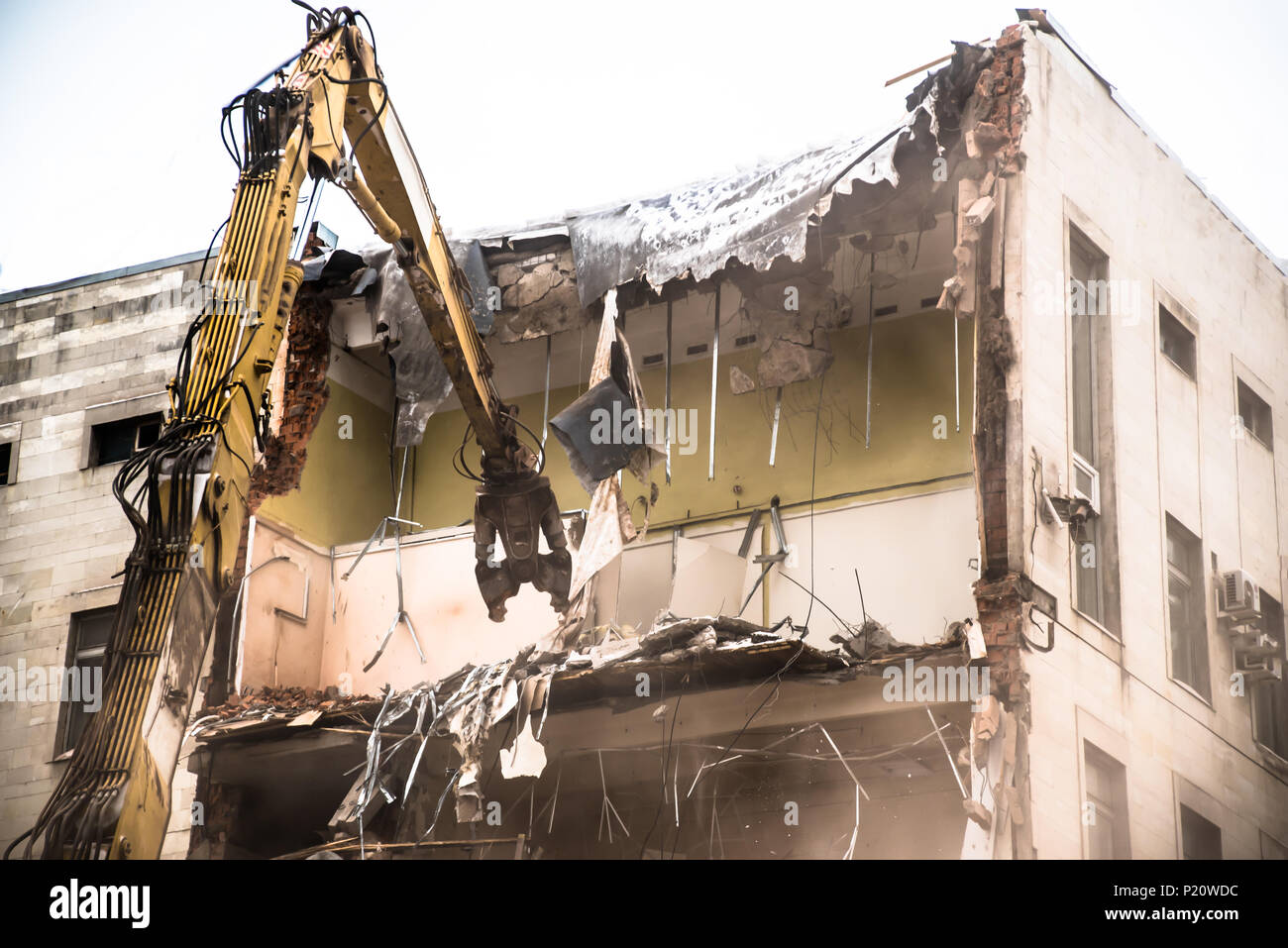 Deconstruction of an old building by hydraulic crasher Stock Photo - Alamy