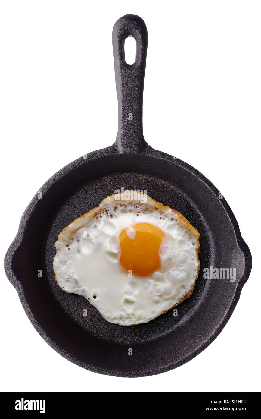 Food: single fried egg on a black ironcast frying pan, isolated on ...