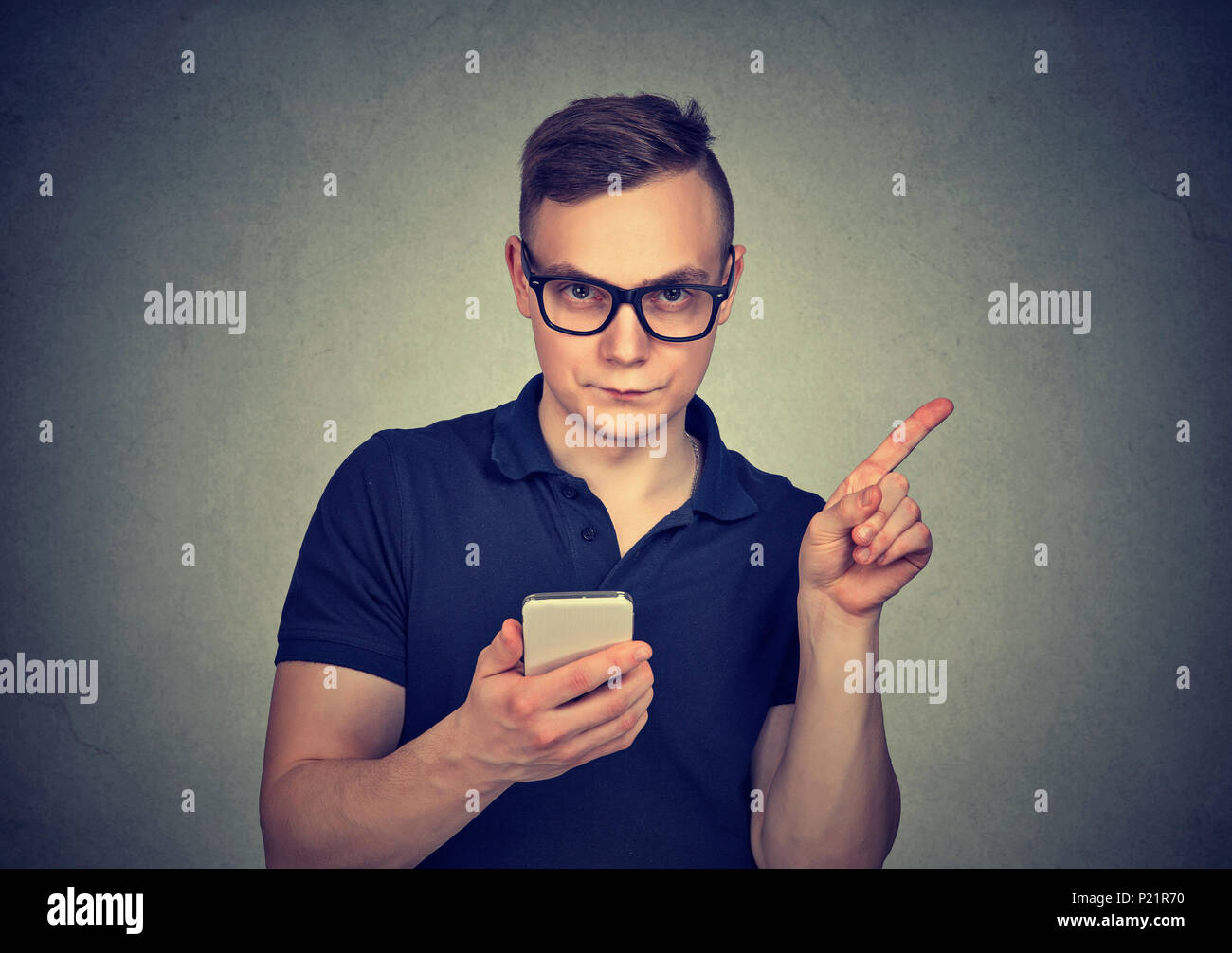 Man with smartphone showing no, attention with finger hand gesture ...