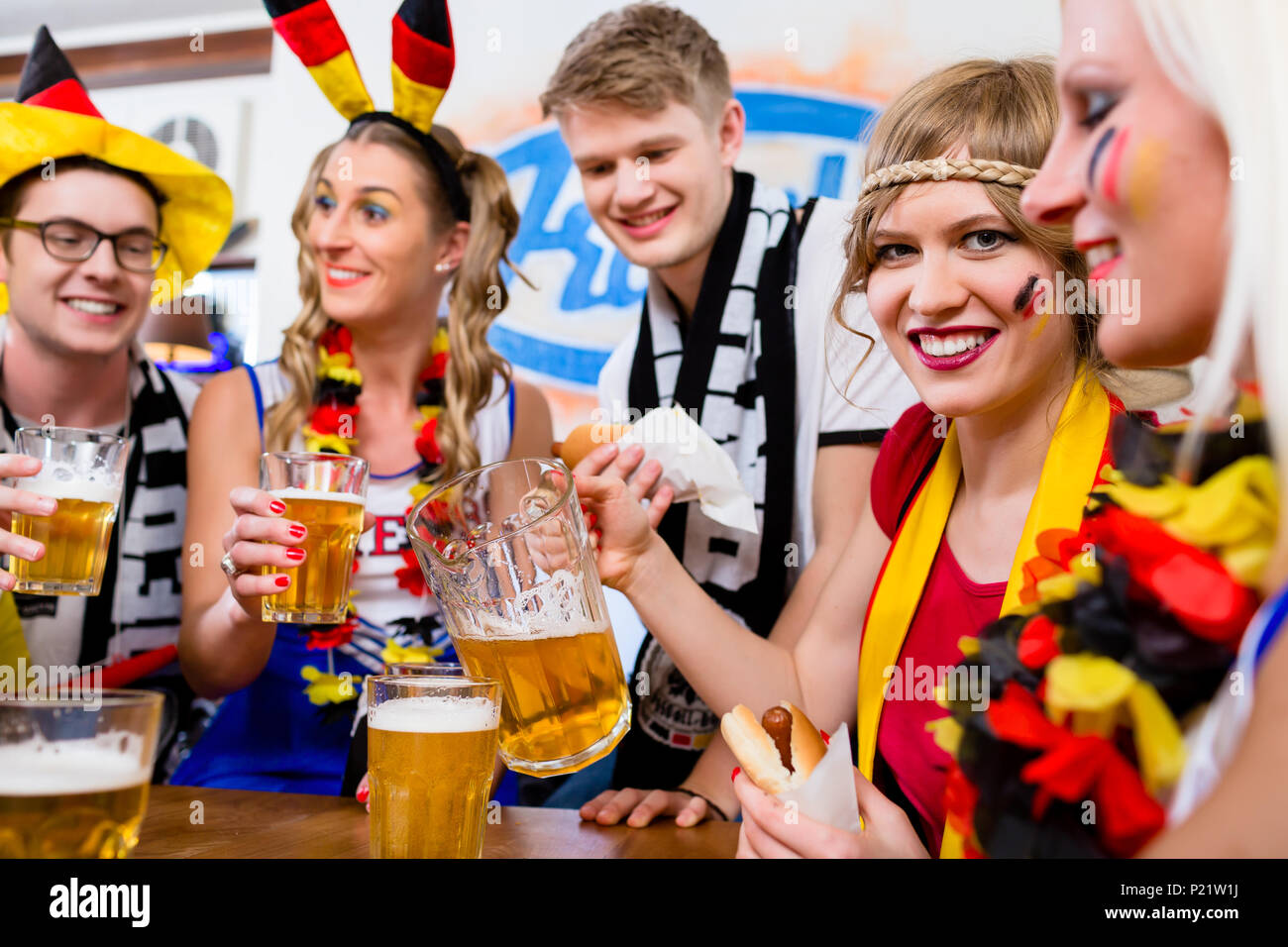 Football fans watching a game of the German national team drinking beer ...