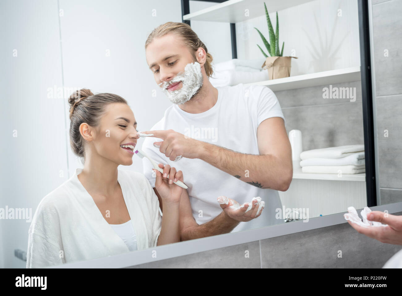 portrait of cheerful couple having fun while doing morning routine ...