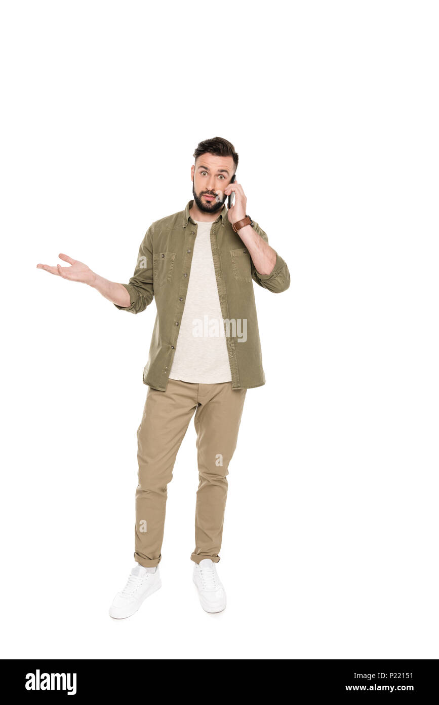 confused man looking at camera while talking on smartphone isolated on ...