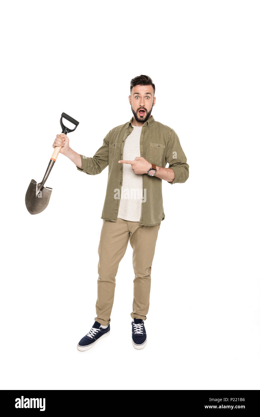 shocked man pointing at shovel in hand and looking at camera isolated ...