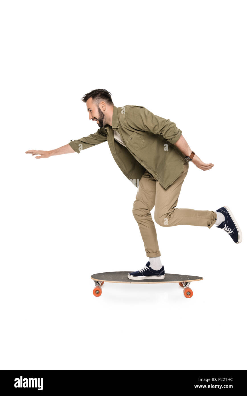 side view of happy young man riding longboard isolated on white Stock ...
