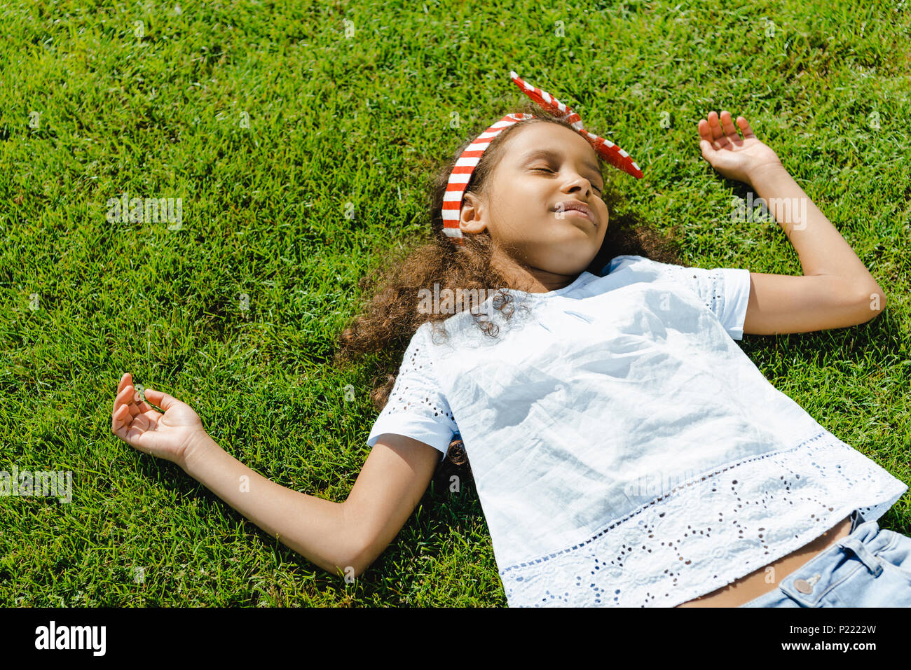 Beautiful little african american girl sleeping on green grass Stock ...