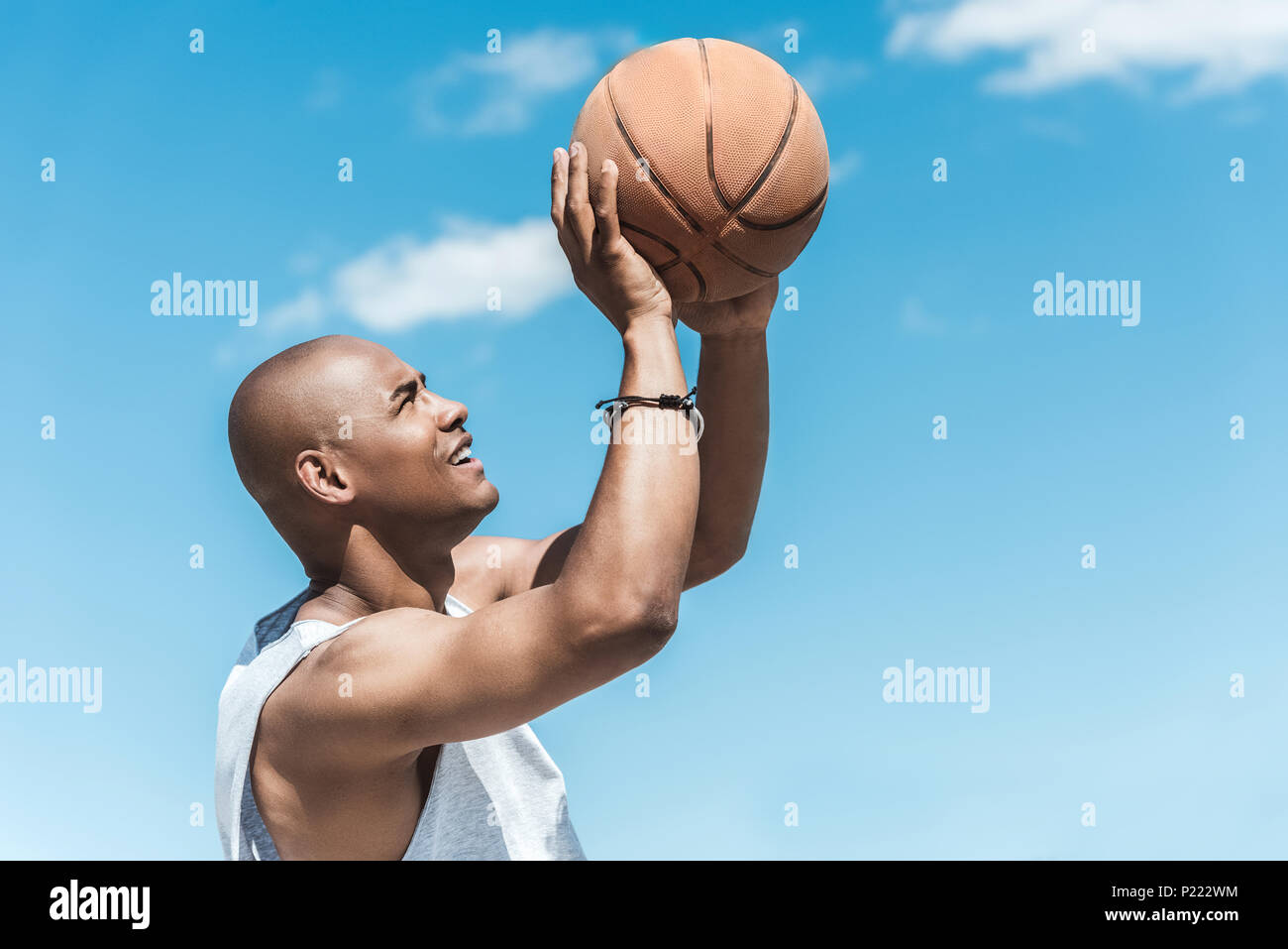 side view of basketball player throwing ball against blue sky Stock ...